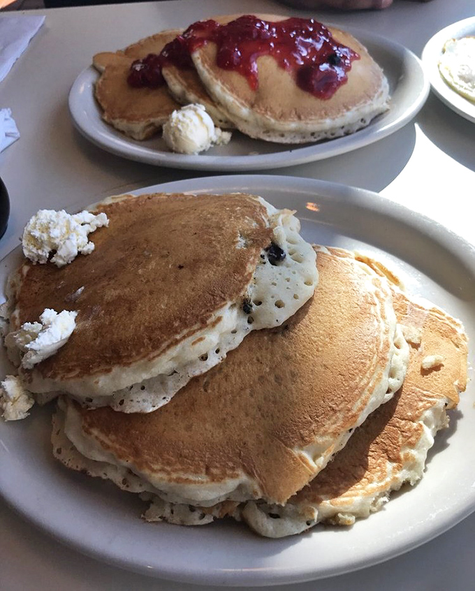 Pancakes stacked higher than my weekend ambitions. The berry topping isn't just delicious&mdash;it's technically a serving of fruit, which makes this health food, right?