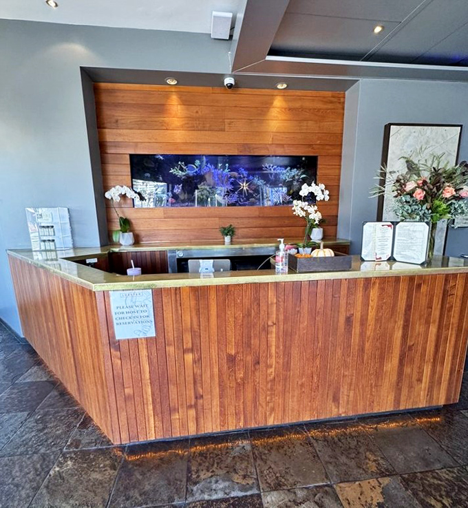 The reception area blends warm wood with sleek design, like a fancy yacht that decided to drop anchor and serve incredible seafood instead.