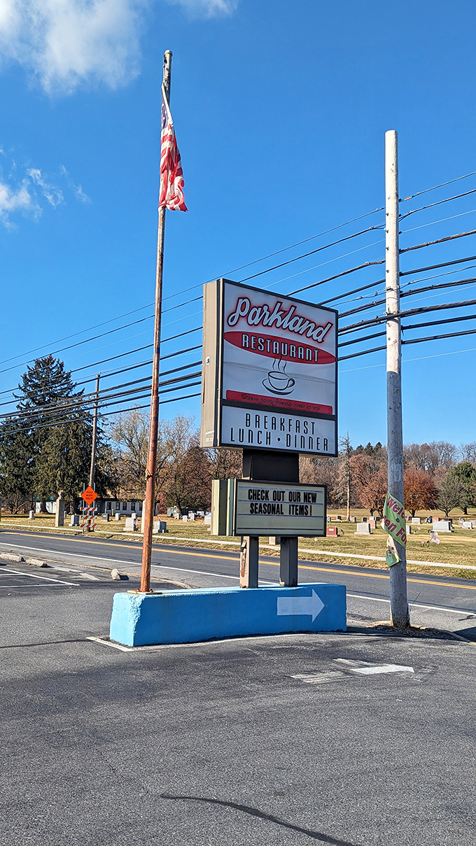 The roadside sign stands like a beacon of breakfast hope, promising pancakes and possibilities to weary travelers and locals alike.