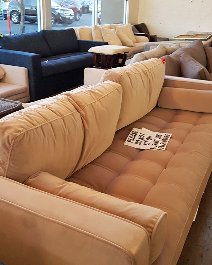 The "please do not sit" sign can't hide the fact that these pristine couches are practically begging to become the centerpiece of someone's living room.