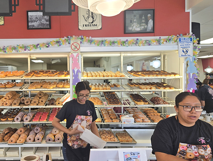 Behind every great donut empire stands a team of pastry wizards. The display case behind them? A museum of edible art.