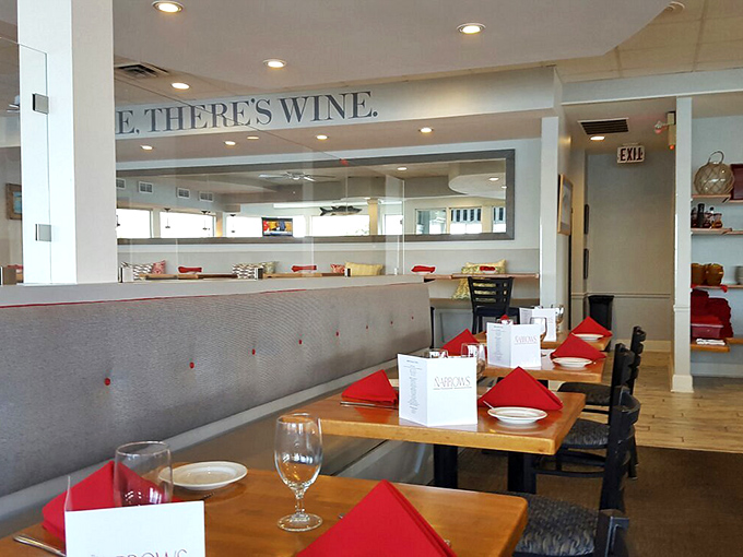 The "SMILE THERE'S WINE" philosophy extends to every corner of the dining room, where red napkins add pops of color to tables awaiting hungry guests.