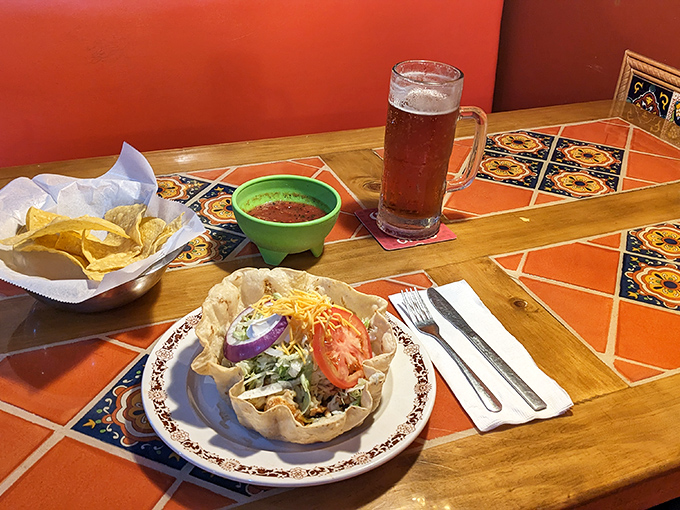 A taco salad that's actually a work of art – the crispy shell forming a canvas for layers of fresh ingredients and a cold beer standing by for support.