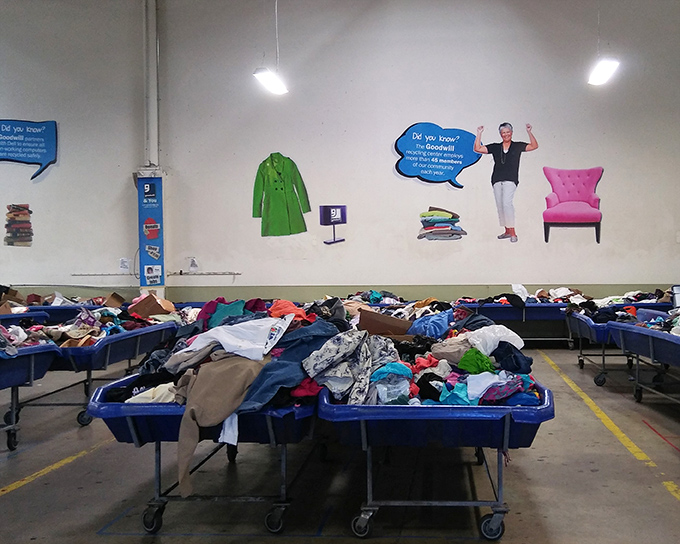 Rows of blue bins create the landscape of discovery. The wall art reminds shoppers that donations do more than find new homes&mdash;they create opportunities.