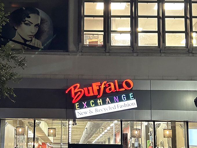 As evening falls, Buffalo Exchange's glowing sign beckons fashion-forward bargain hunters looking for designer labels at delightful prices.