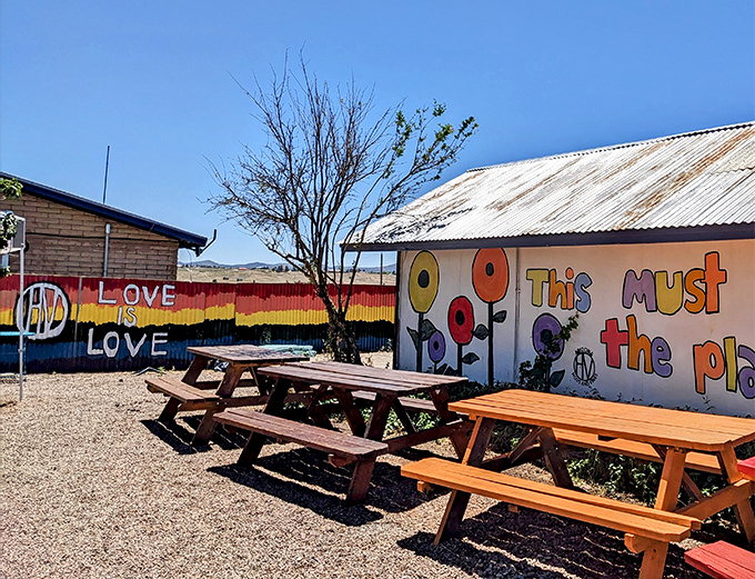 Colorful murals and rustic picnic tables create an inviting oasis in Sonoita's wine country, where western heritage meets artistic spirit.
