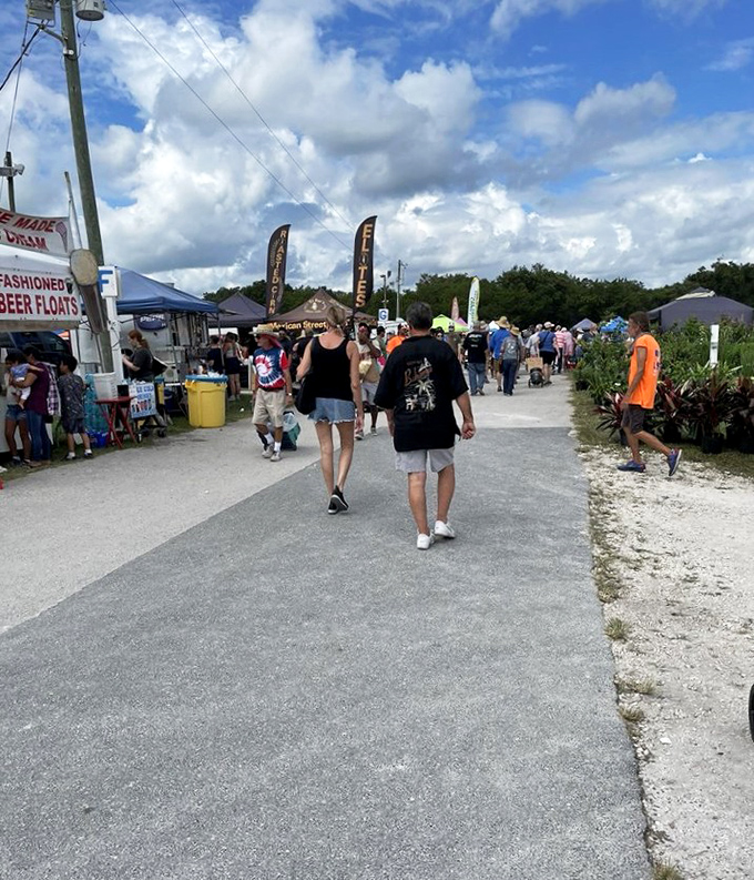 Nature meets commerce at Webster, where flowering plants create a colorful border around vendor areas.