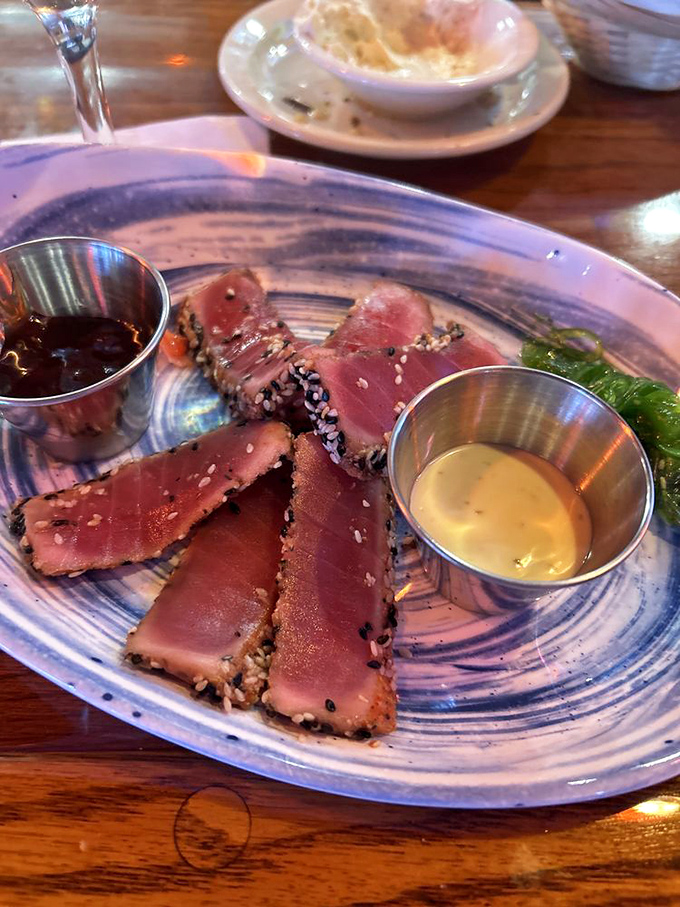 Sesame-crusted tuna, seared rare and sliced with precision. Two dipping sauces because life's too short to commit to just one flavor profile.