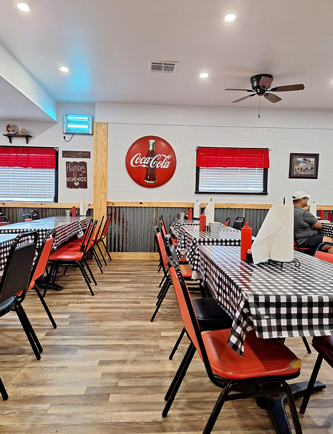 Black and white checkered tablecloths add a touch of diner nostalgia to this dining room where the Coca-Cola sign isn't decoration&mdash;it's a promise.