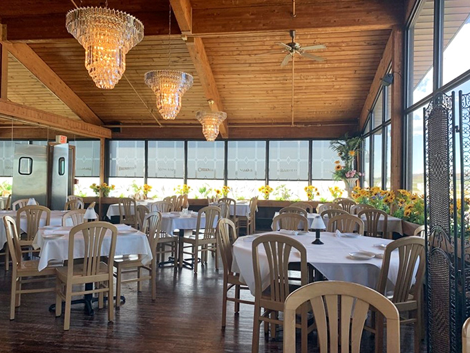 White tablecloths meet wooden beams in this sunlit dining area where every table feels like the best seat in the house.