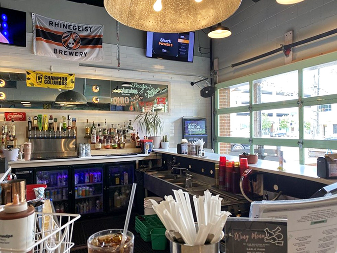 The bar area showcases local pride with Ohio flags and brewery banners &ndash; because good BBQ deserves equally thoughtful beverage companions.