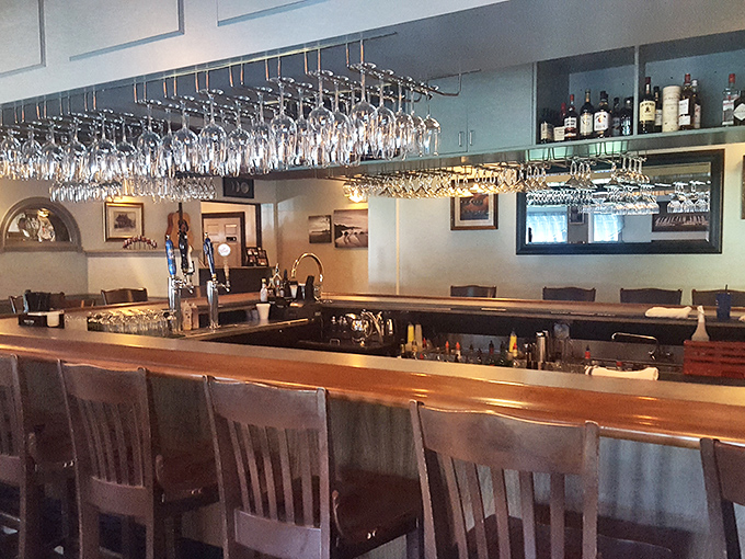 The bar stands ready for service, where glasses hang like crystal stalactites waiting to capture your libation of choice.