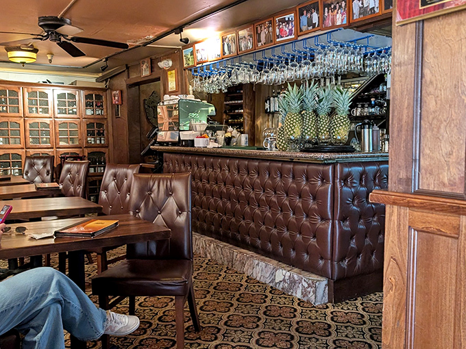 The bar area feels like it's been there forever, with tufted leather, hanging glassware, and pineapples that whisper, "Yes, your vacation cocktail is totally justified."