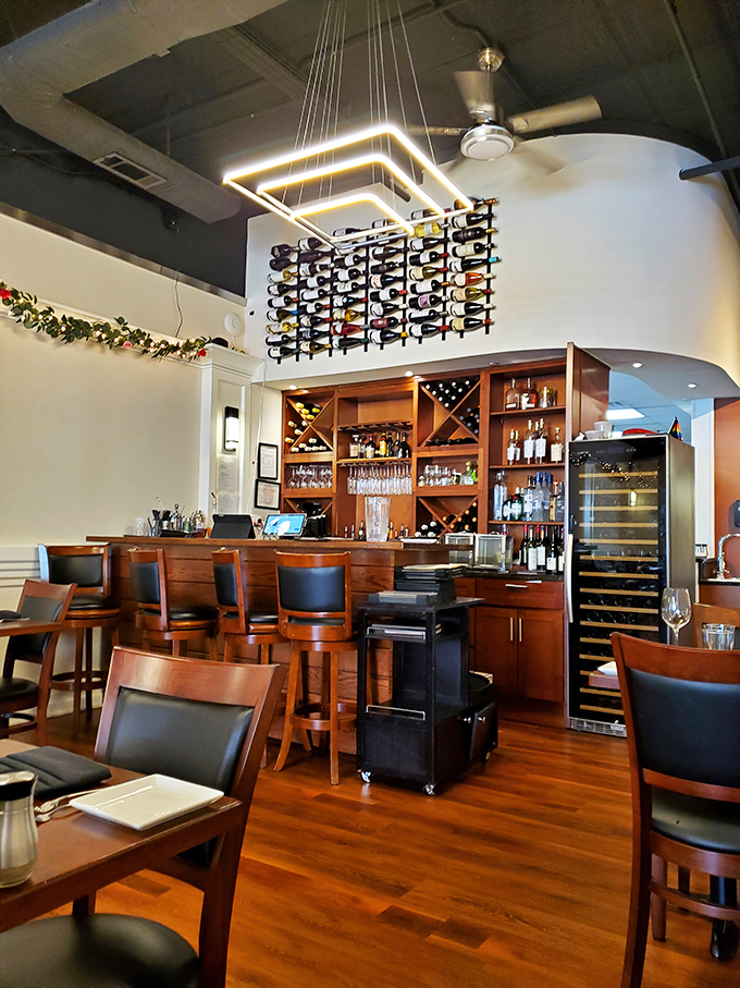 A wine display that would make Bacchus weep with joy, hovering above a bar area that beckons you to linger longer.