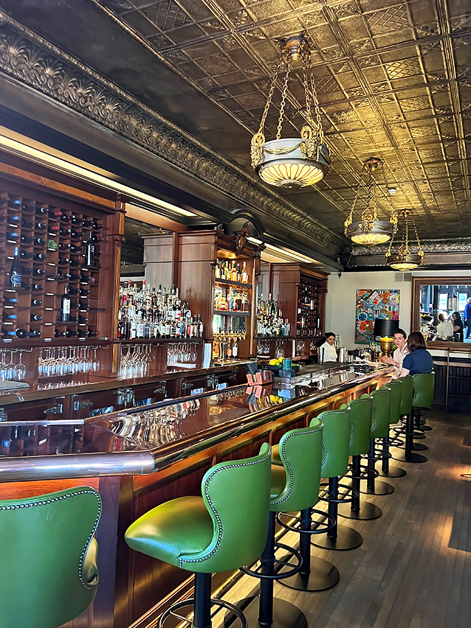 A bar that understands the difference between "having a drink" and "having an experience"—green leather seats included.