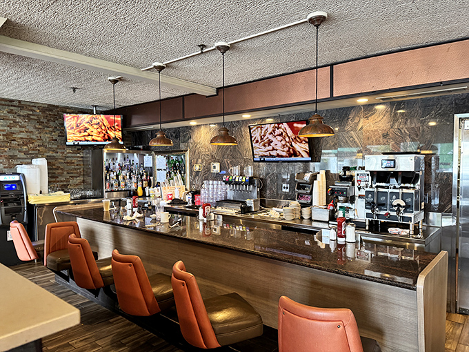 The bar area gleams with promise, where pendant lights cast a warm glow over granite countertops that have witnessed countless coffee refills and life stories.