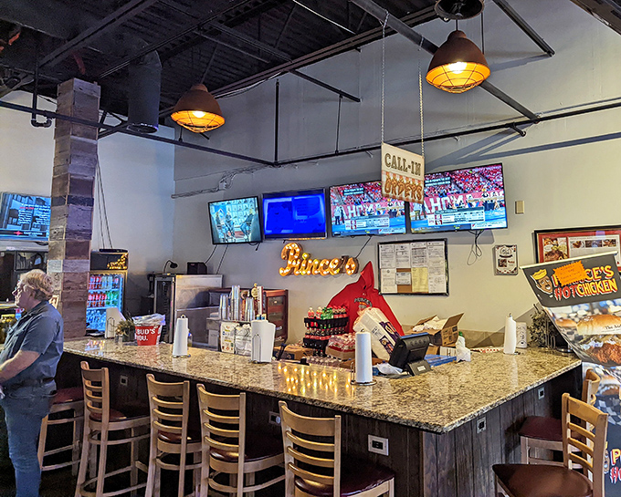 The bar area offers front-row seats to the hot chicken action. Notice the multiple TVs – perfect for pretending you're not crying from the heat.