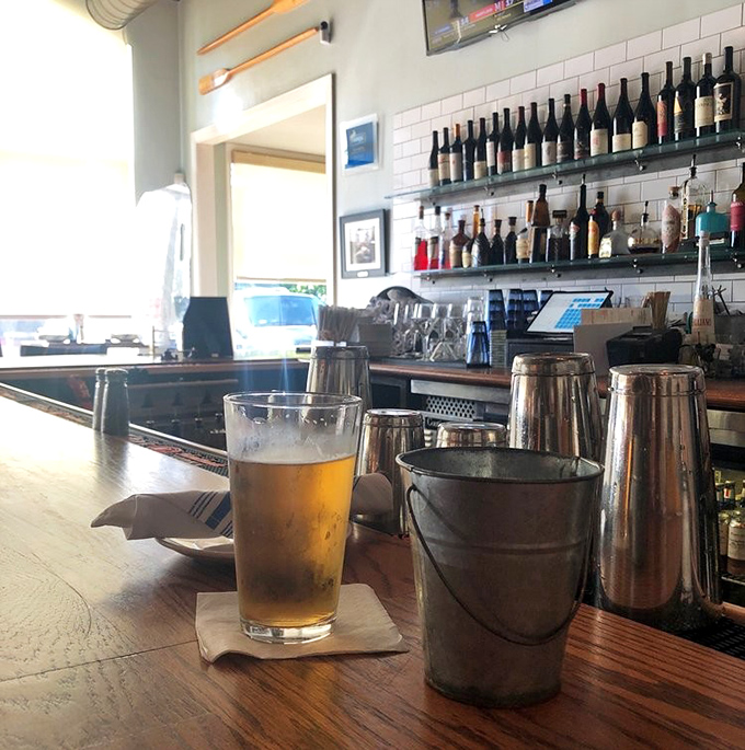 The bar's impressive lineup of spirits stands ready for duty, like a well-trained crew awaiting orders from the captain of your palate.