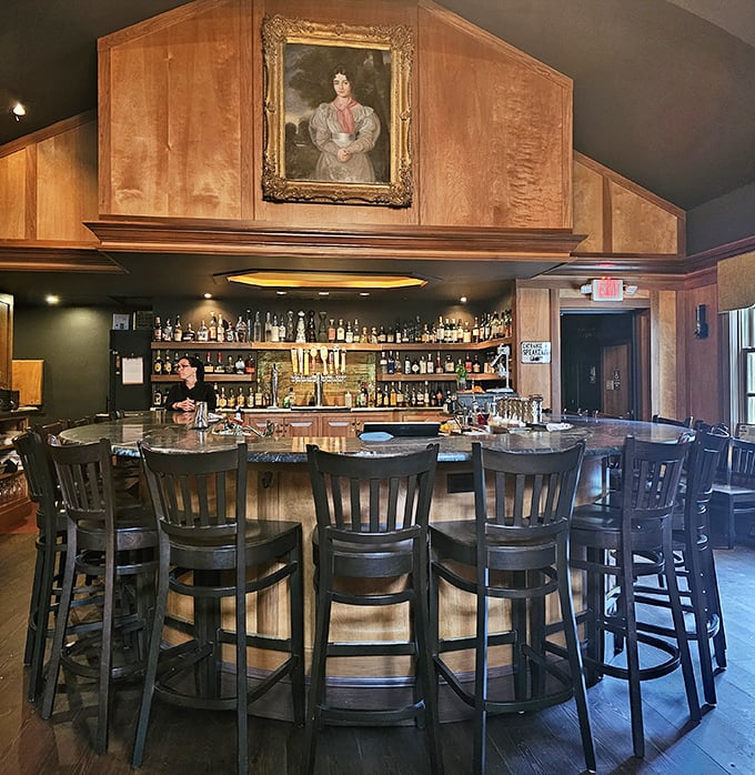 A circular bar that invites storytelling, where crafted cocktails are poured beneath watchful eyes of Pennsylvania's past in gilded frames.