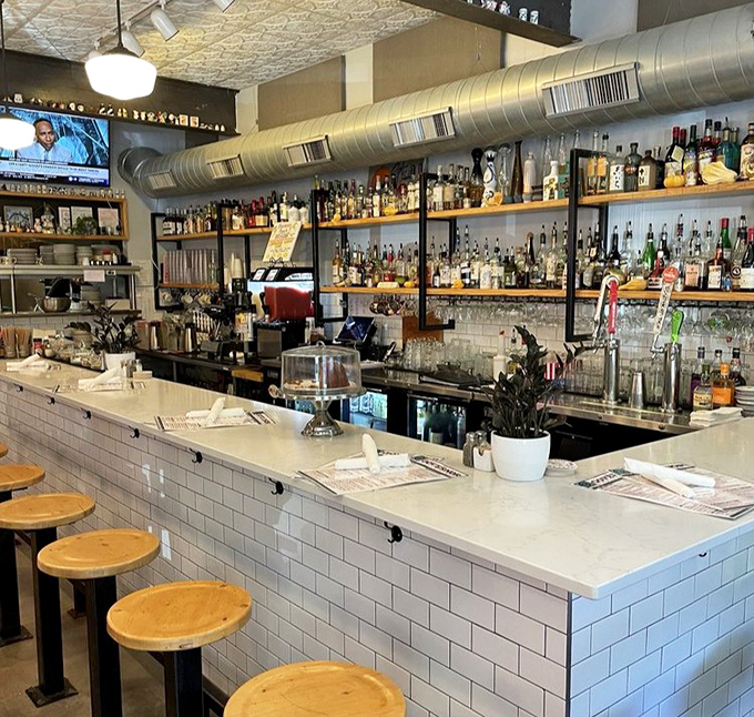 Behind that gleaming bar, bottles stand at attention like soldiers ready to serve in the noble cause of crafting the perfect cocktail.