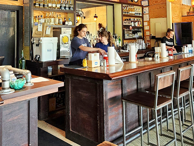 Behind every great burger joint is a bar that understands its supporting role. The wooden shelves lined with bottles promise adventures beyond beef.