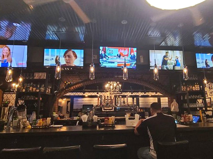 The bar area combines sports bar energy with deli authenticity. Those pendant lights aren't just illuminating the space&mdash;they're spotlighting potential happiness.