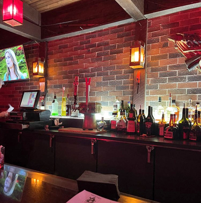 The bar beckons with bottles arranged like soldiers at attention, ready to serve your libation of choice under the warm glow of pendant lights.