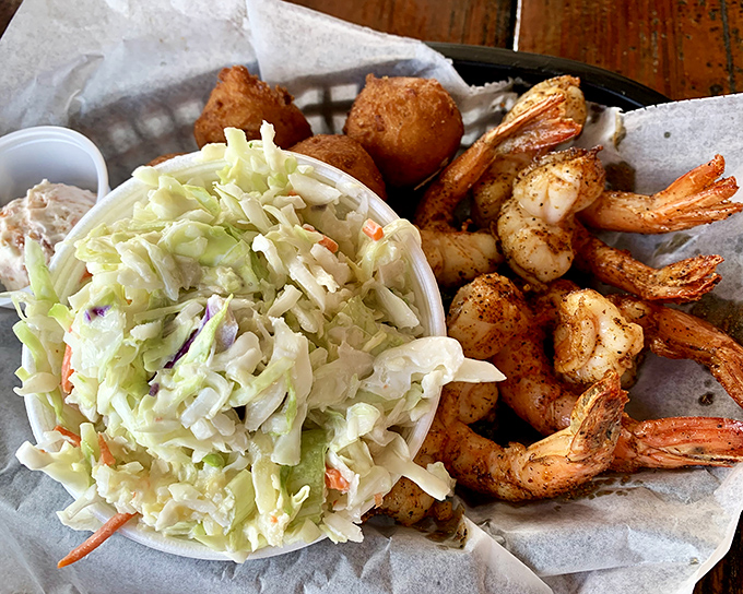 The holy trinity of coastal comfort: perfectly blackened shrimp, creamy coleslaw, and hush puppies that would make your Southern grandmother weep.