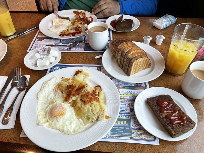 Breakfast perfection on white plates—eggs with just-right yolks, crispy potatoes, and toast standing by for dipping duty.
