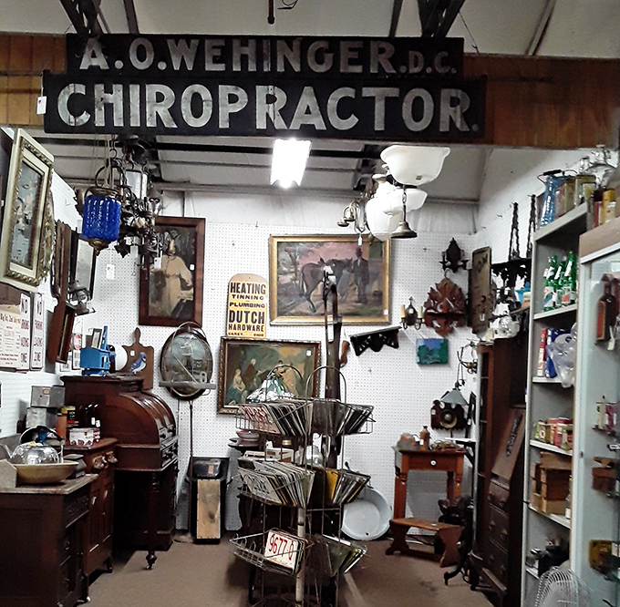 Dr. Wehinger's vintage chiropractic sign looms over a booth packed with curiosities. Your wallet might need an adjustment after visiting.