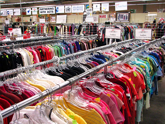 Color-coded clothing racks create a thrifter's rainbow, where yesterday's fashion finds become tomorrow's signature style statements.
