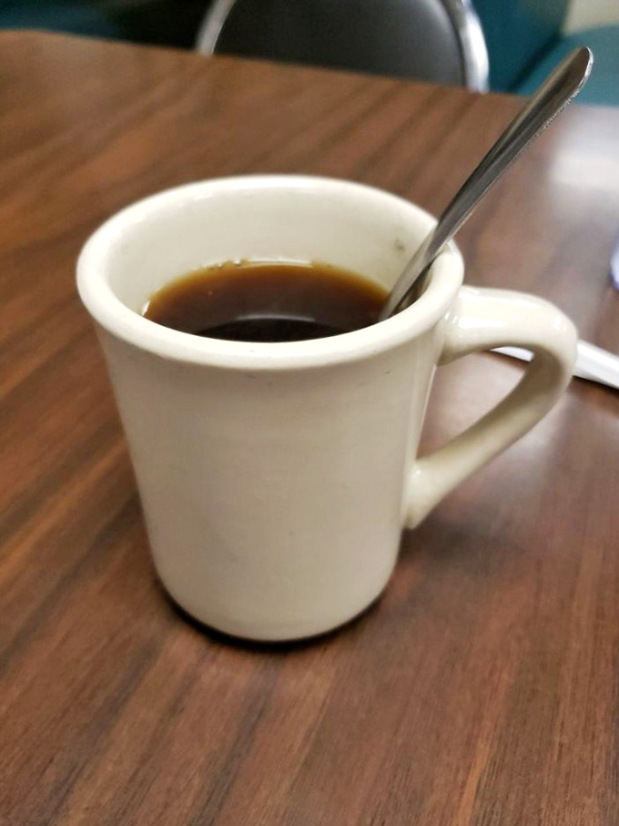 The simple white diner mug—holding what's likely the fuel that powers all of Fort Worth through the morning hours, no fancy latte art required.