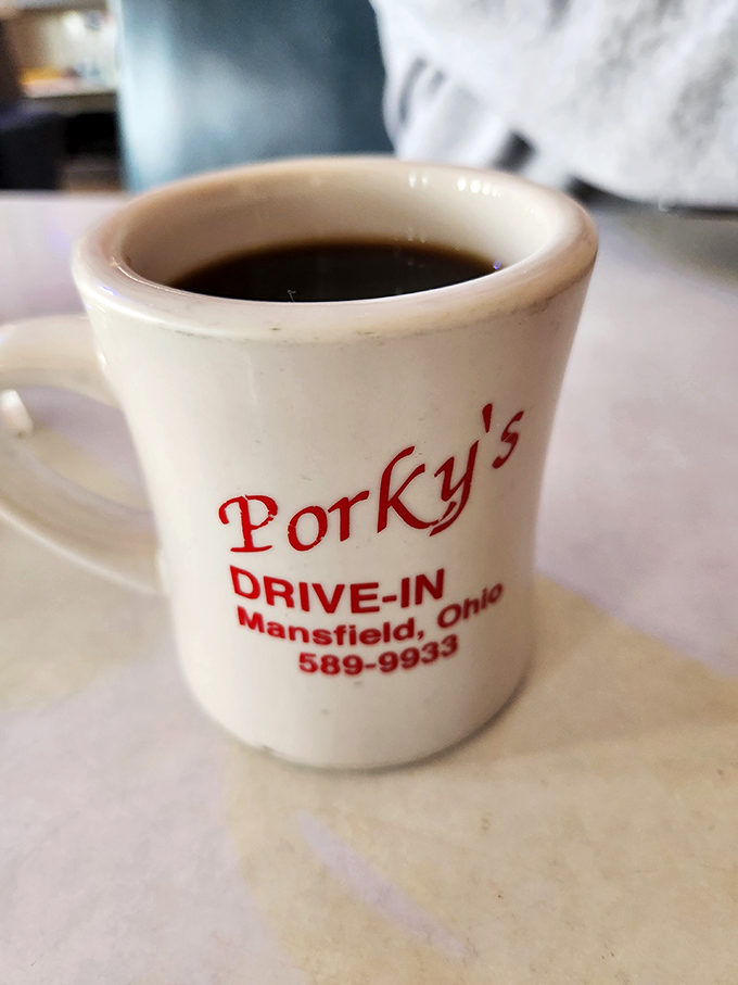 The coffee mug says it all—no fancy latte art needed when you've been serving liquid motivation since Eisenhower was president.