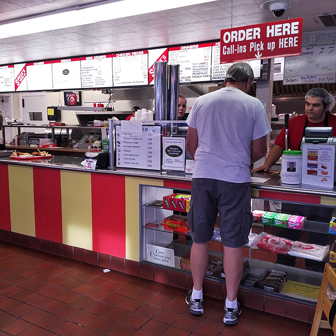 The moment of anticipation at the counter&mdash;where hunger meets hope. That red and yellow striped fa&ccedil;ade promises satisfaction is just minutes away.
