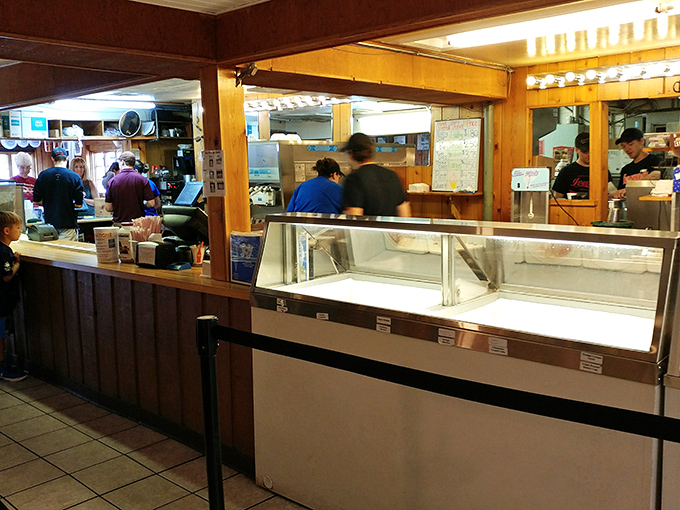 The counter where dreams are ordered, assembled, and delivered. Behind that glass lies cold, creamy possibility.