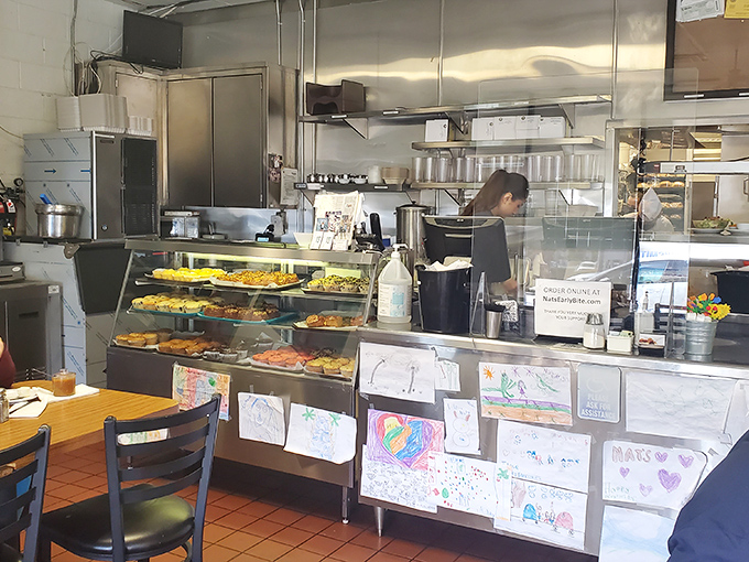 The bustling counter area showcases a display case of temptations and walls adorned with the artwork of young fans.