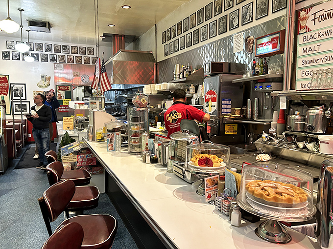 The counter where magic happens. Pies tempt from glass cases while staff choreograph the beautiful dance of short-order cooking behind the gleaming surface.