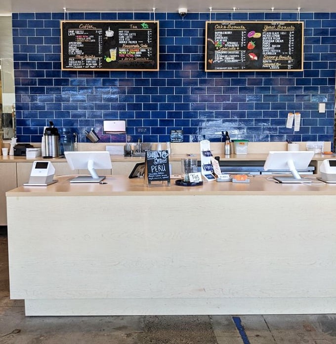 Behind this counter, donut dreams come true. The vibrant blue tile backdrop makes the wooden menu boards pop like works of culinary art.
