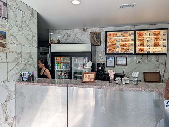 Behind this counter, sandwich artisans perform their daily magic. Notice the "CASH ONLY" sign—another charming throwback to simpler times.