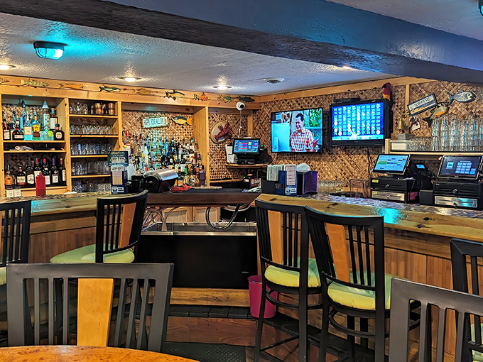 The tiki-inspired bar area, complete with bamboo accents and colorful lighting, serves up vacation vibes alongside creative cocktails.