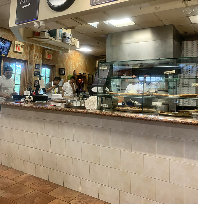 Where the magic happens: skilled hands working behind the counter, transforming simple ingredients into Italian-American classics before your eyes.