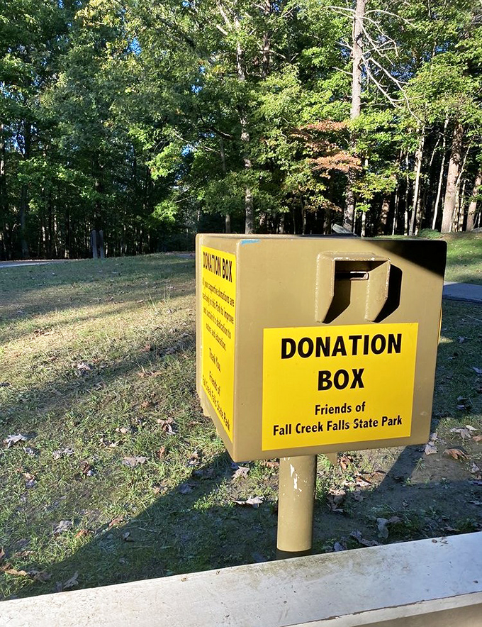 The humble donation box stands guard, silently suggesting that maintaining paradise costs more than just good intentions and proper trash disposal.