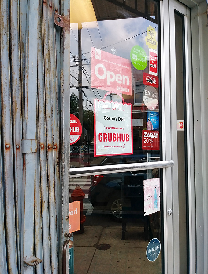 The gateway to gastronomic bliss. Delivery stickers and accolades adorn the entrance, hinting at the culinary treasures that await inside.