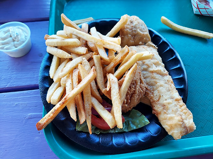 Fish and chips served on a black plate that makes the golden batter pop like fireworks. Simple food done right is always a masterpiece.