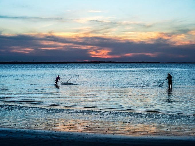 Twilight fishermen cast their nets into the painted waters. Their silhouettes create a scene worthy of a gallery wall.