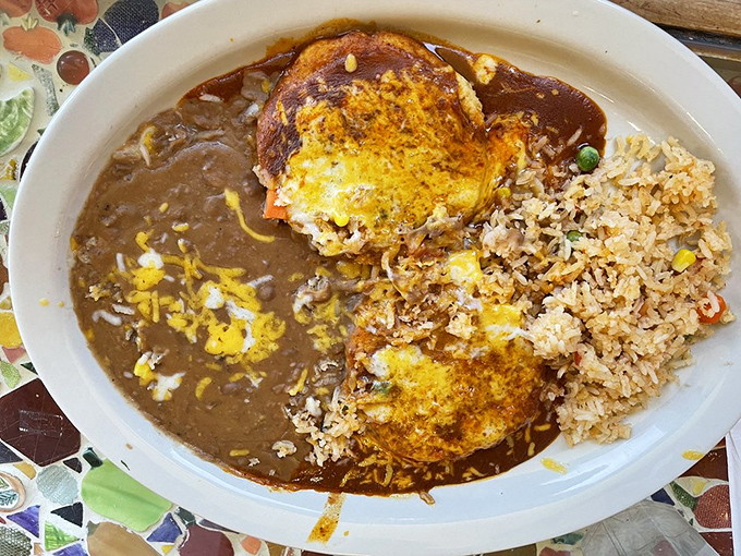 Flat enchiladas spread wide with sauce and cheese, proving sometimes the best things come unrolled.