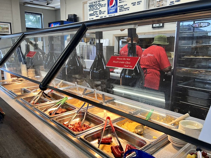 Behind the glass lies a kingdom of comfort - each metal pan a throne for Southern classics that have earned their royal status.