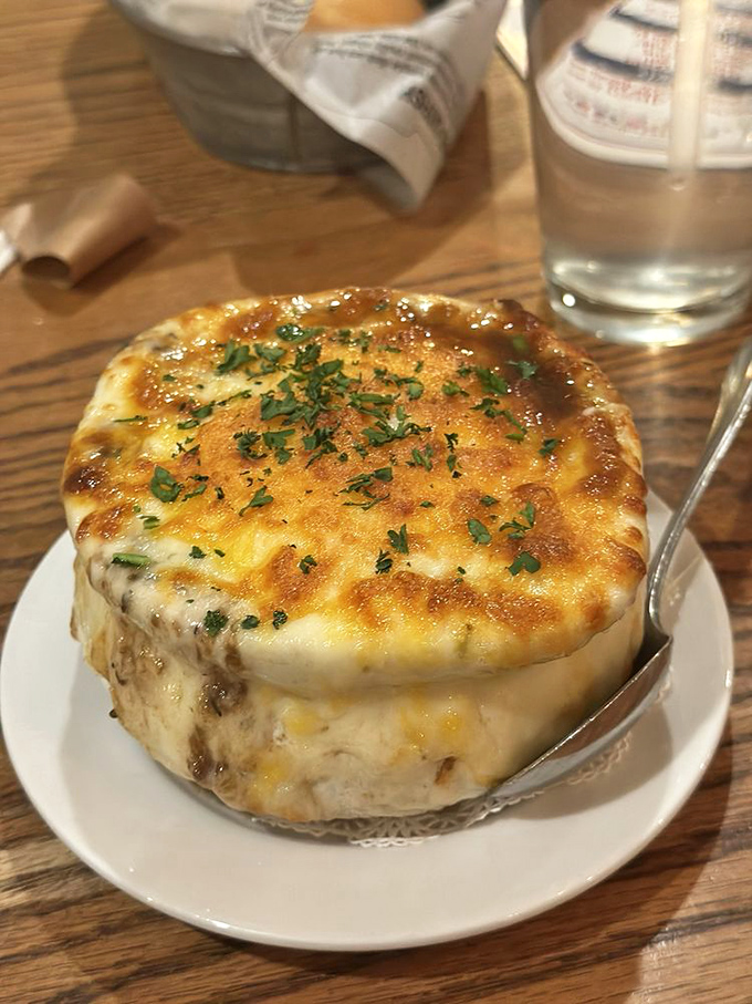 French onion soup wearing its cheese crown proudly, a bubbling masterpiece that demands a moment of respectful silence before diving in.