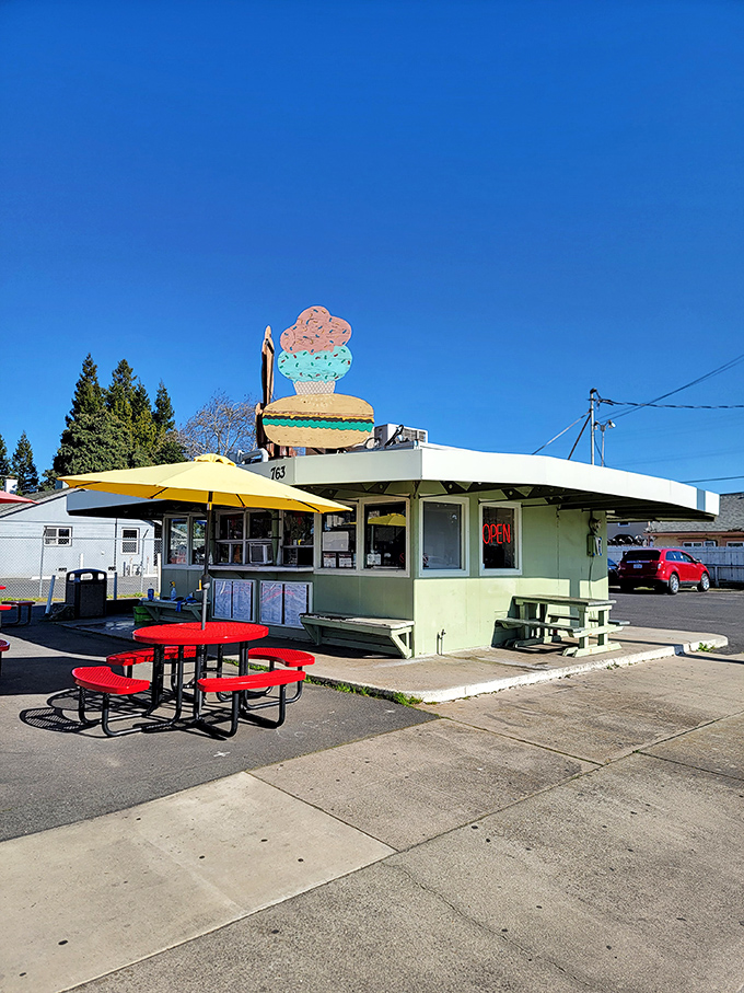That classic mint green drive-in structure stands proud against the California blue sky, unchanged while the world rushes frantically forward.