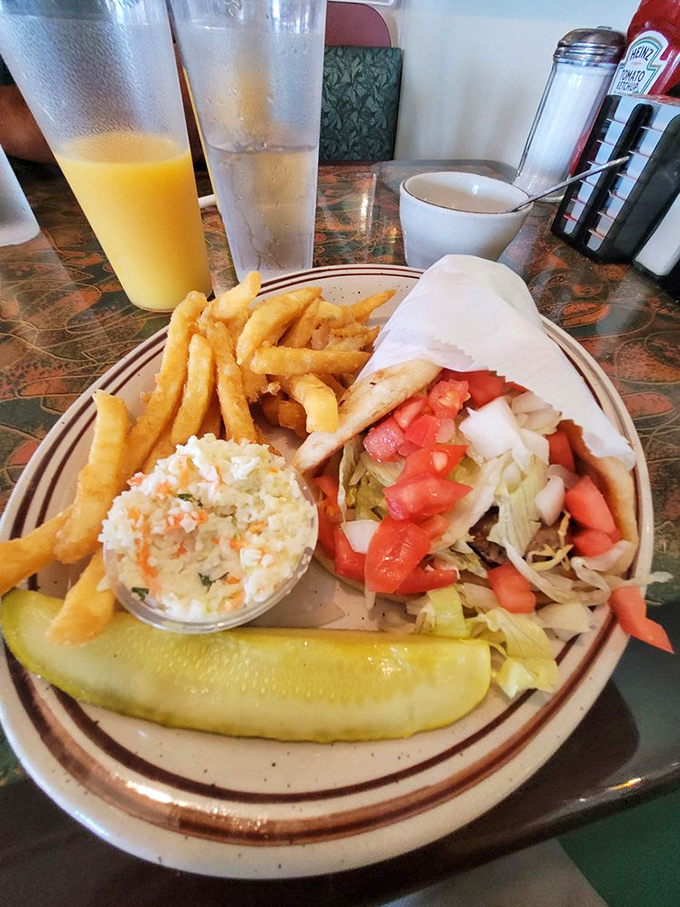 A wrap bursting with fresh vegetables, served with crispy fries and that essential dill pickle spear. Lunch perfection on a plate.